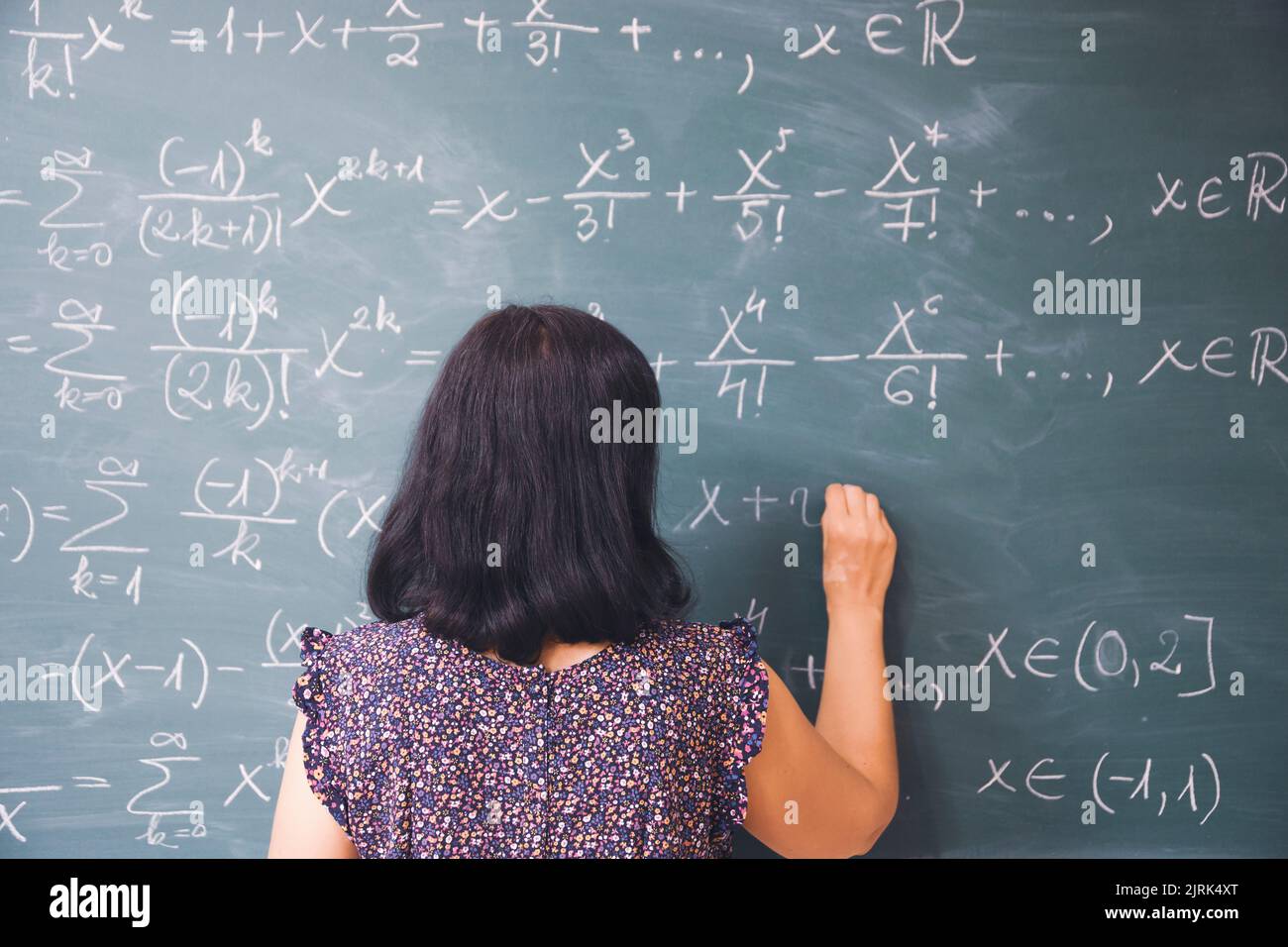 Teacher or student writing on blackboard during math lesson in school ...