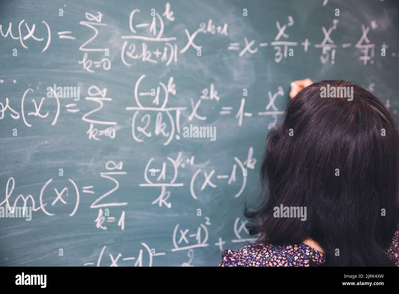 Teacher or student writing on blackboard during math lesson in school ...