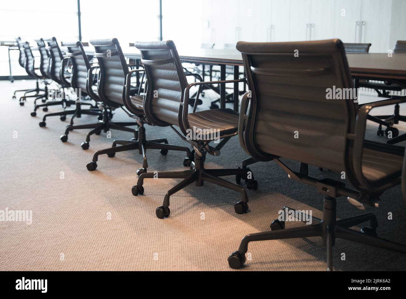 A modern interior design for an office with a long table and chairs ...