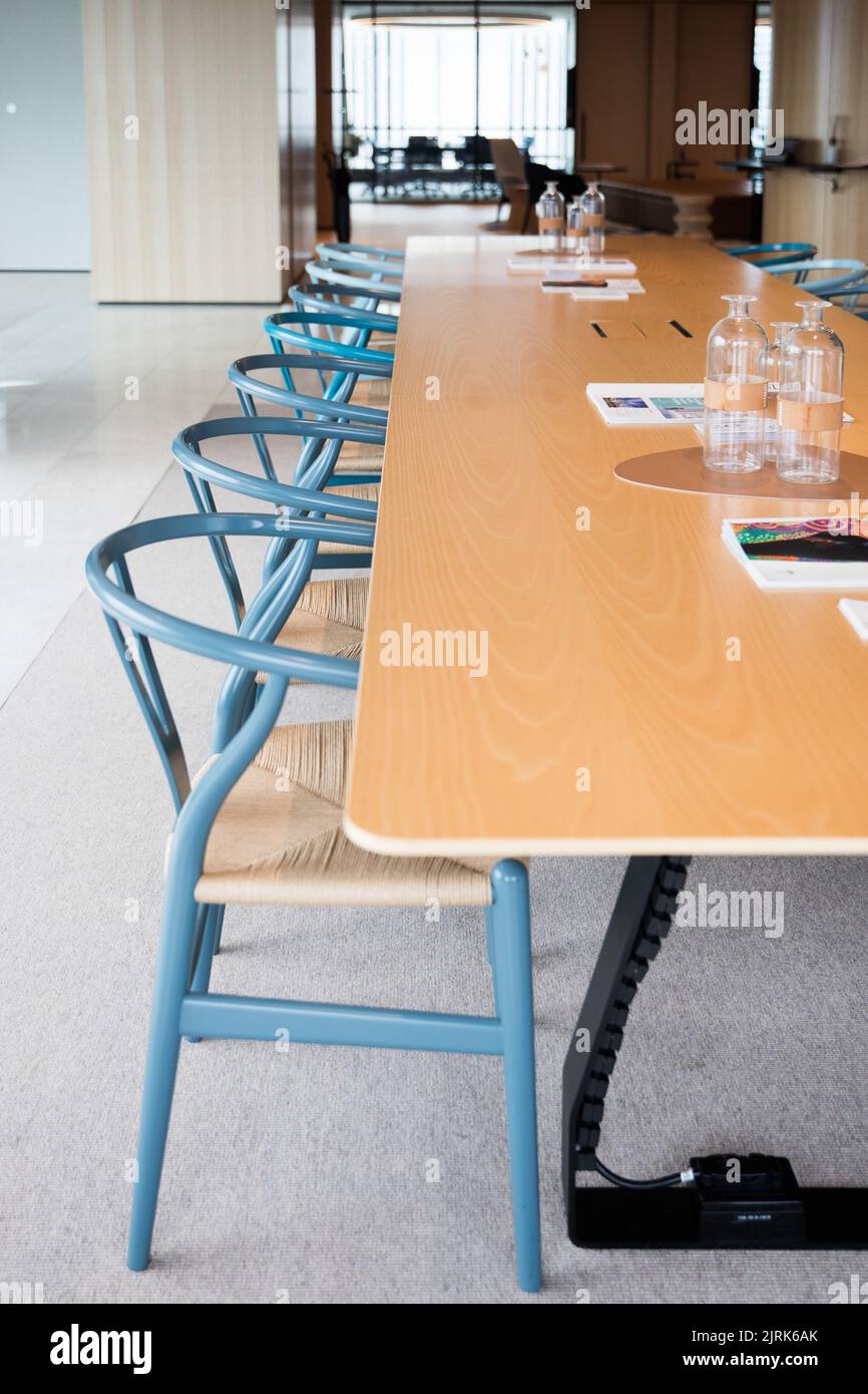 A vertical of modern interior design for an office with a long table ...