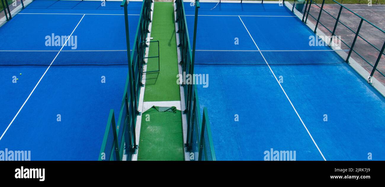two blue synthetic grass paddle tennis courts, racket sports concept ...