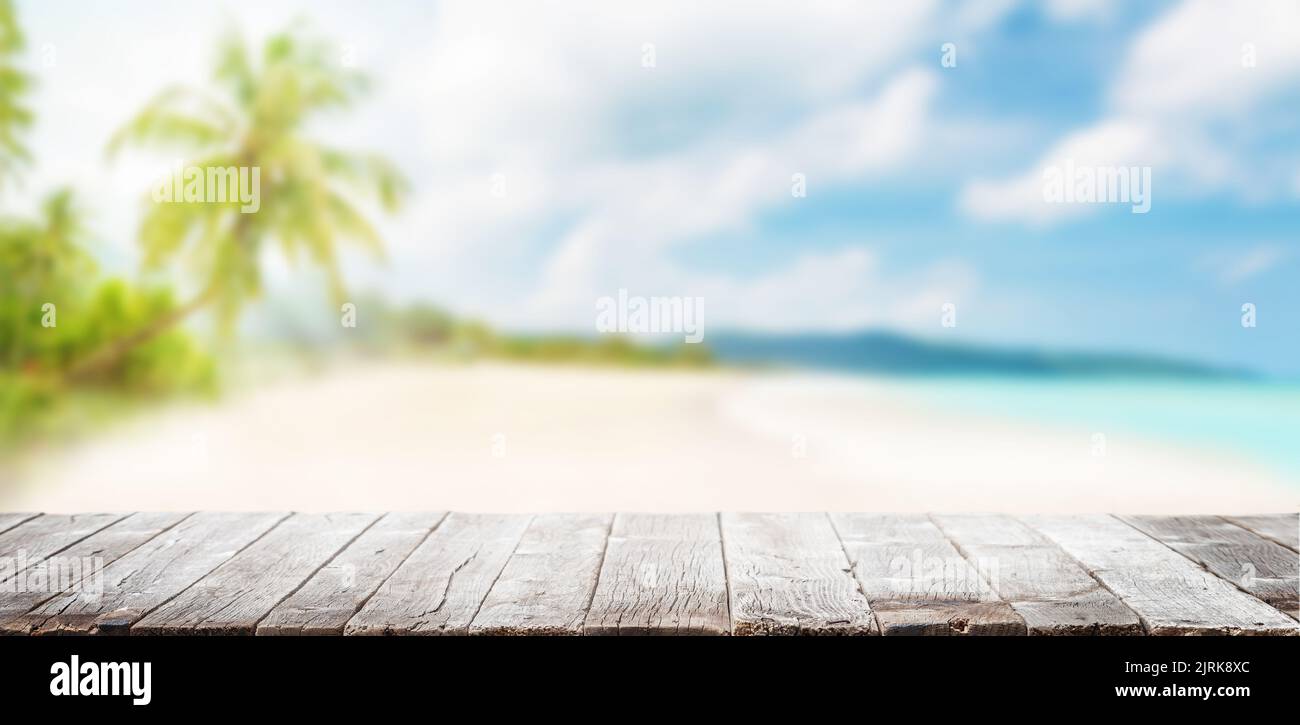 Empty wooden table or pier with sunny beach and sea on background. With ...