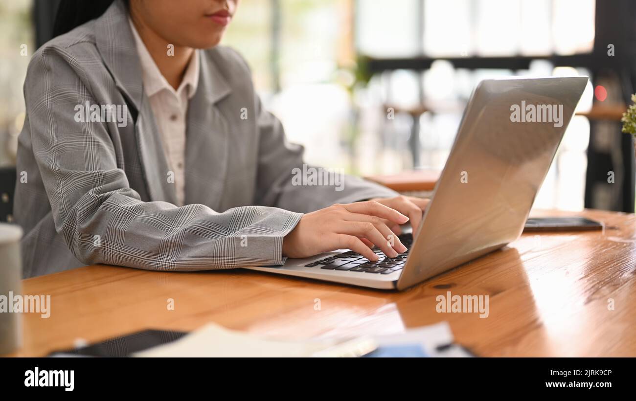 Focused female office worker typing business email or checking online ...