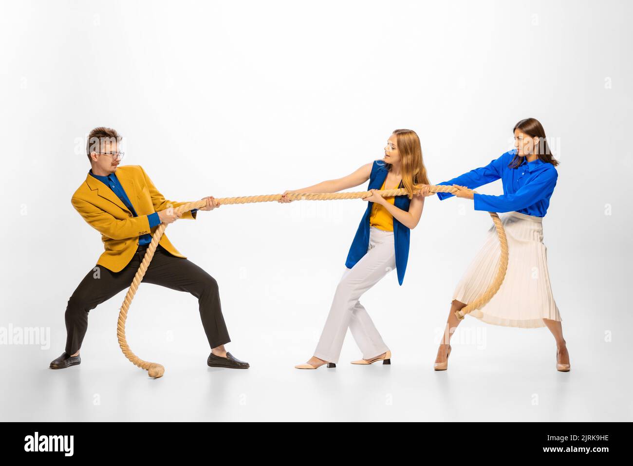 Portrait of two women pulling rope with man symbolizing professional ...
