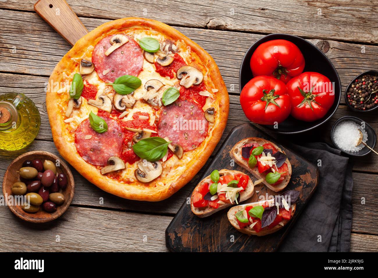 Italian cuisine. Pepperoni pizza and toasts. Flat lay on wooden table ...