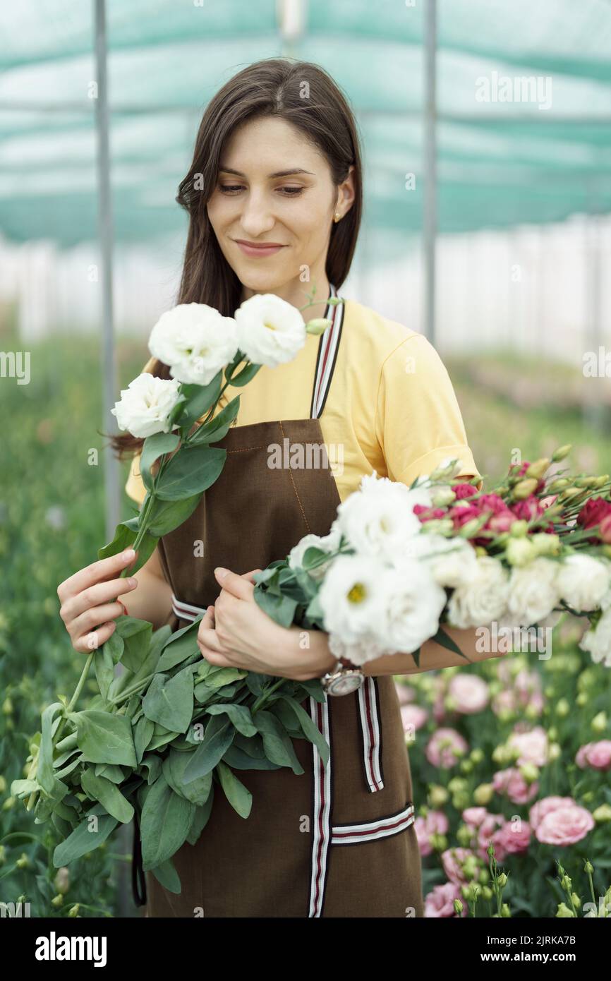 Woman florist has an order for fresh flowers. She makes a beautiful ...