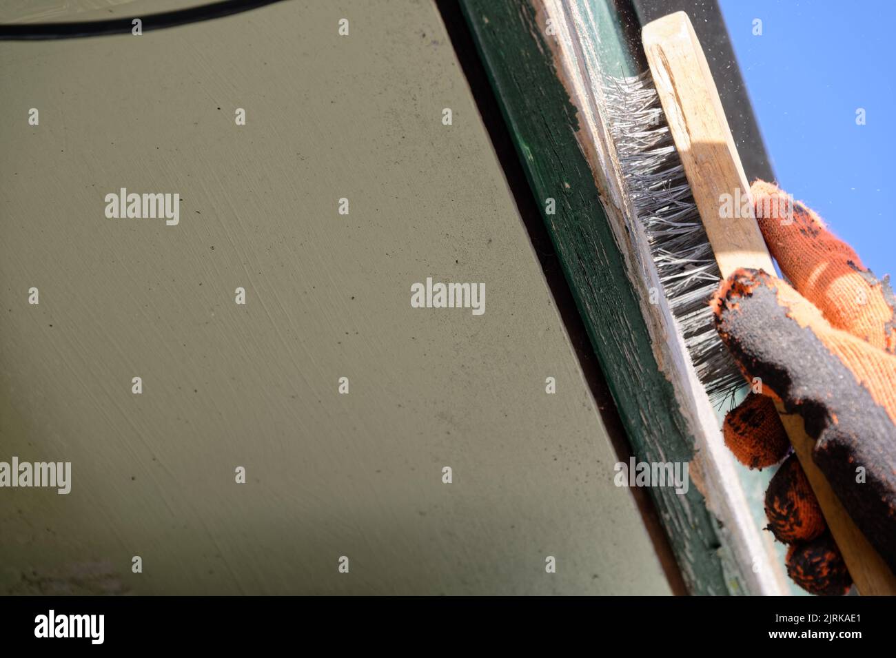 The wire bristles of a wire brush remove loose paint prior to painting ...