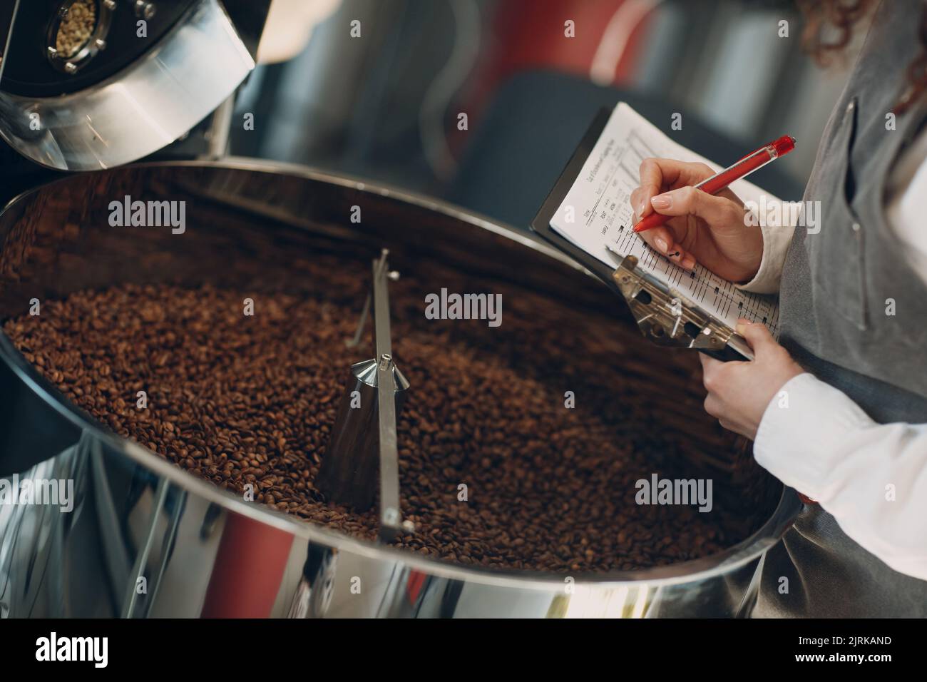 Coffee roaster machine and barista woman with tablet write pen at ...