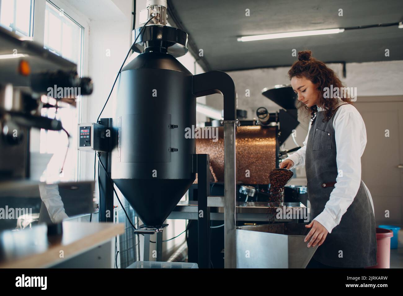 Woman worker at Coffee destoner machine at coffee roasting process ...