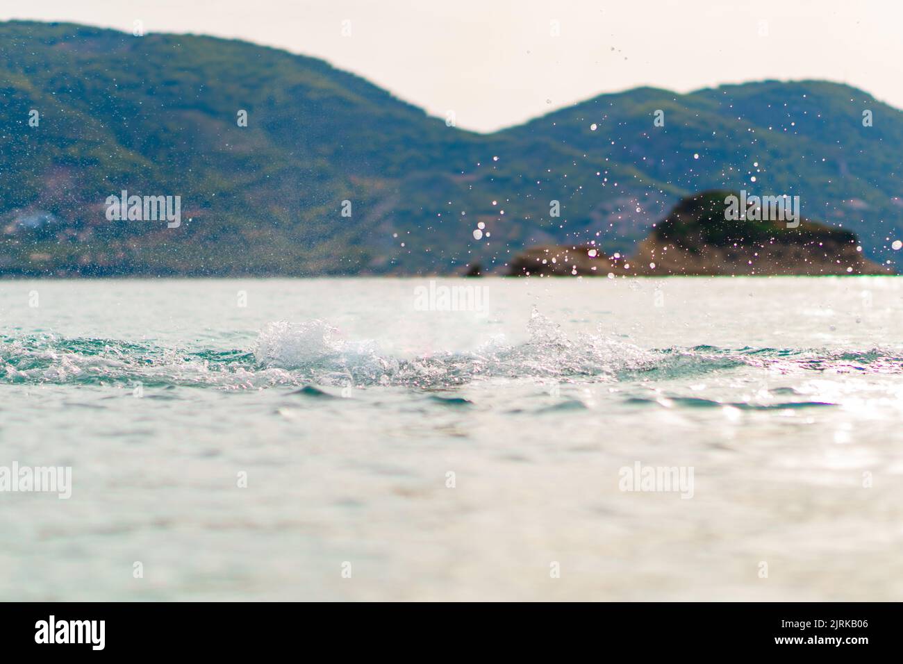 Sea Water Splash With Beautiful Montains Background Stock Photo - Alamy