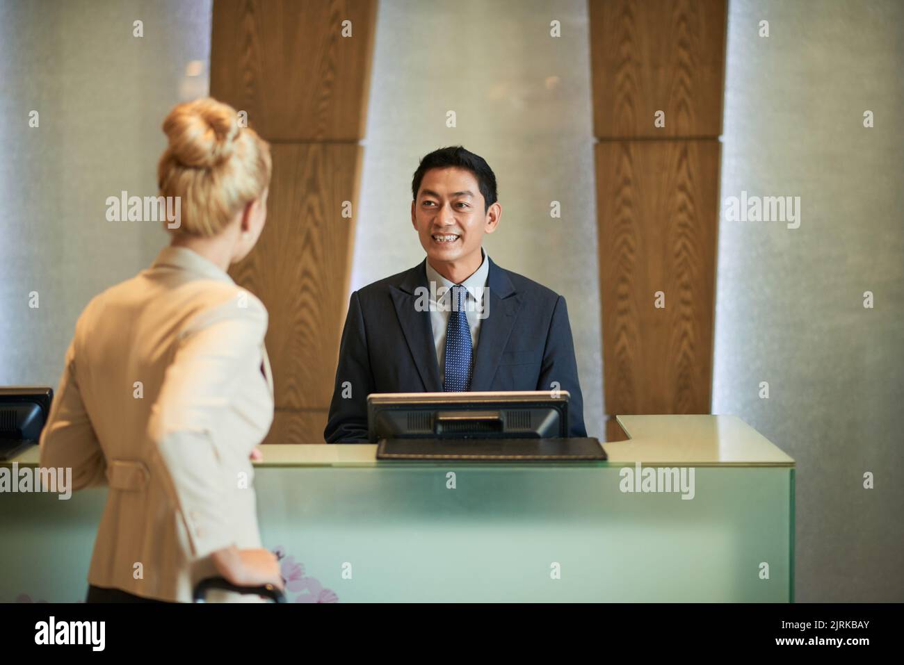 Business lady talking to receptionist of hotel Stock Photo - Alamy