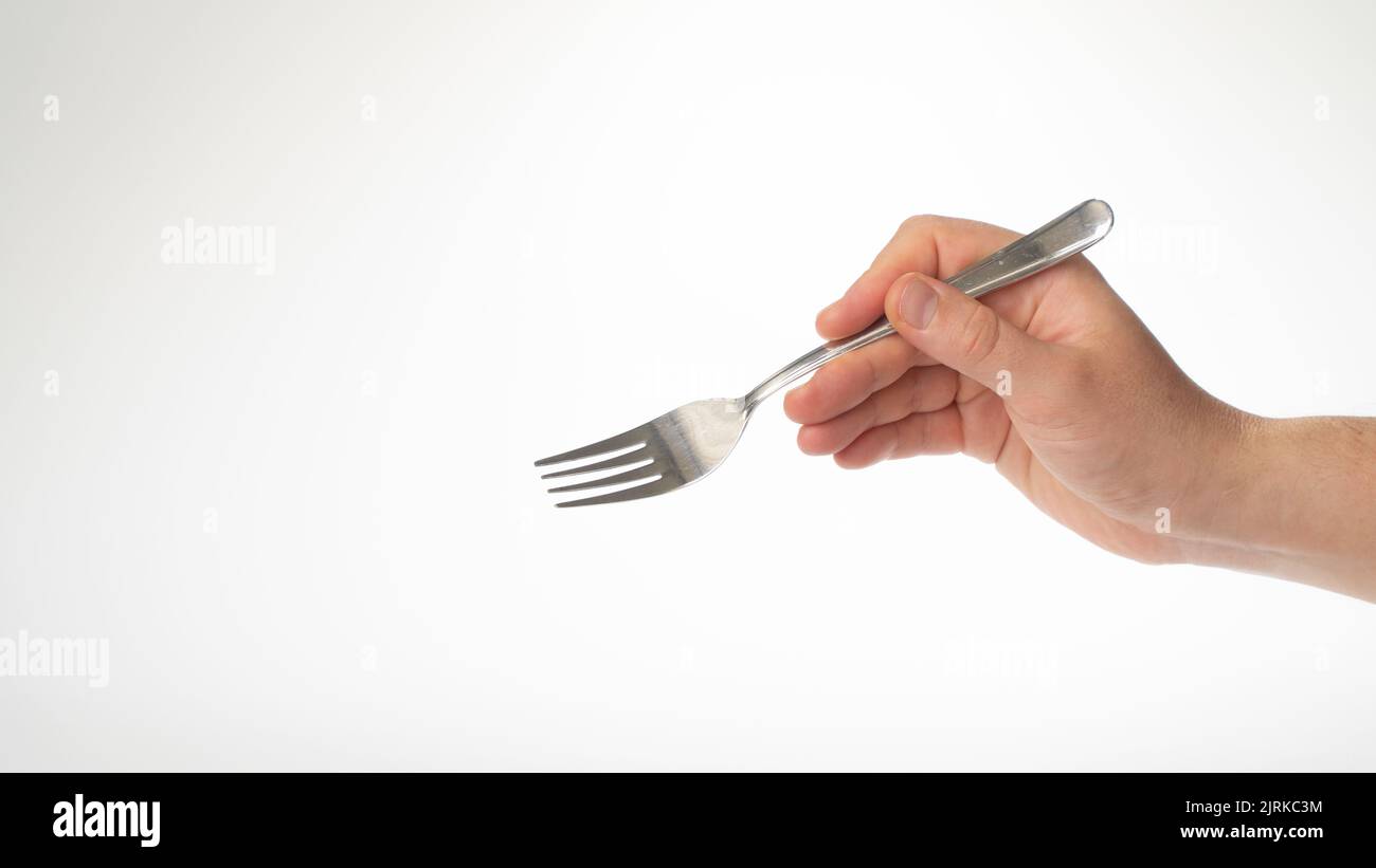 Fork in the right male hand gesture to eat on a white background. High ...