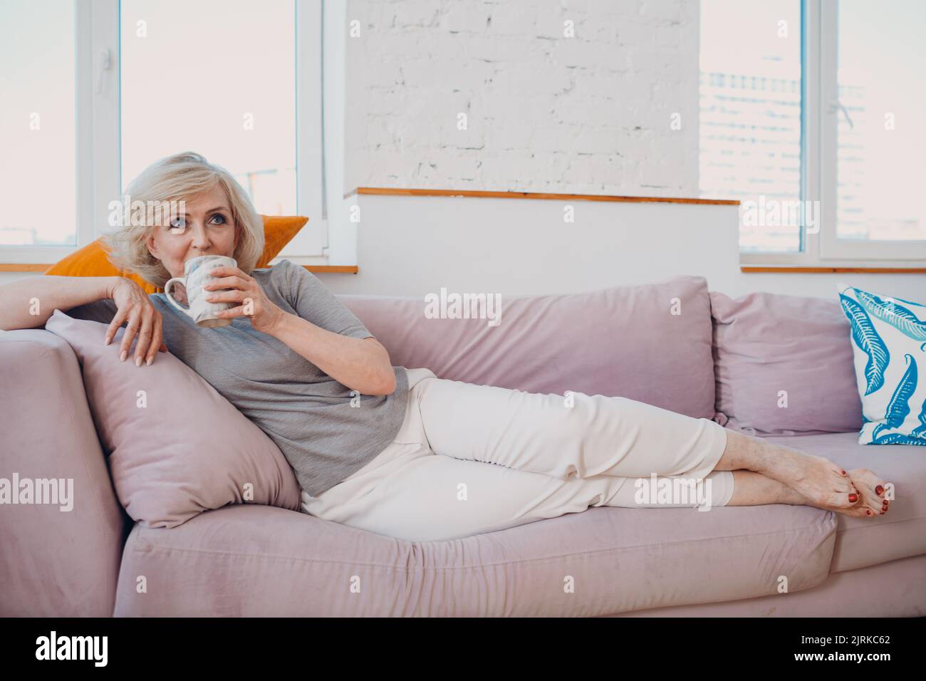Elderly caucasian old aged woman drinking enjoying afternoon tea at ...