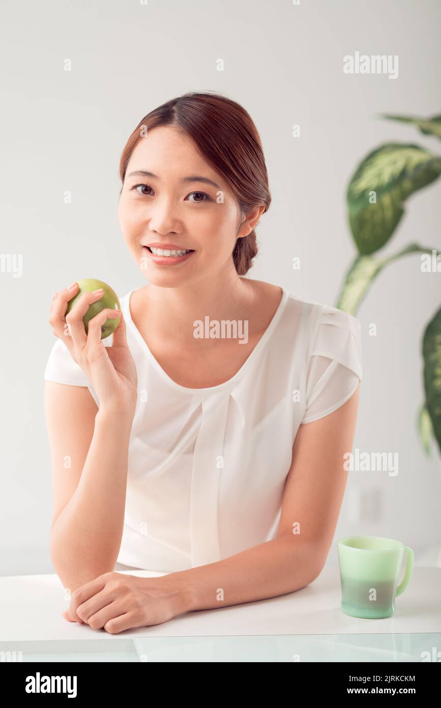 Pretty healthy young business lady eating green apple Stock Photo - Alamy