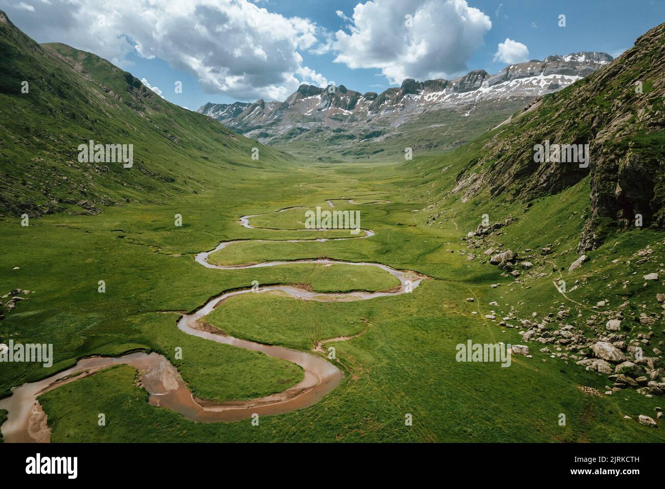 From above green grassy valley with winding trails between mountain ...