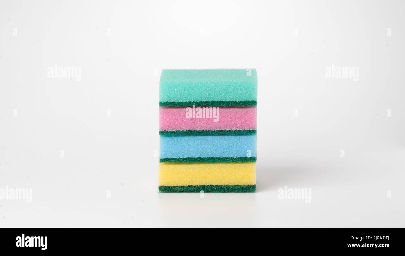 Multicolored four sponges folded into a flat stack on a white ...