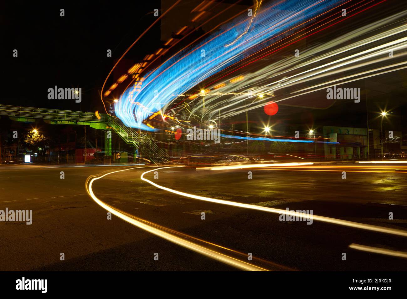 Colorful traffic light trails along road in dark city at night in long ...