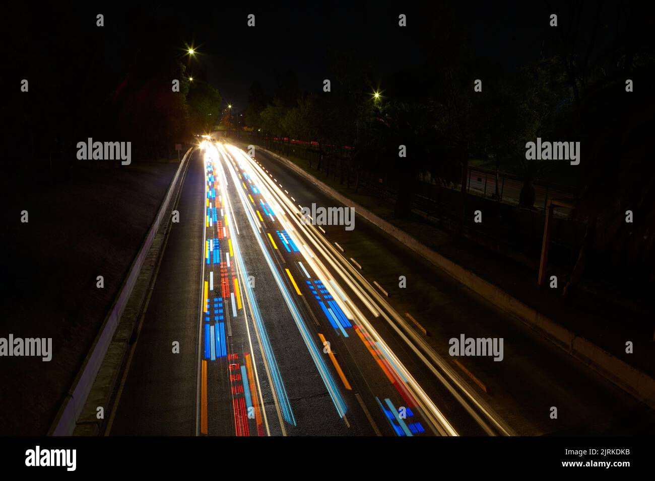 From above of colorful traffic light trails along road in dark city at ...