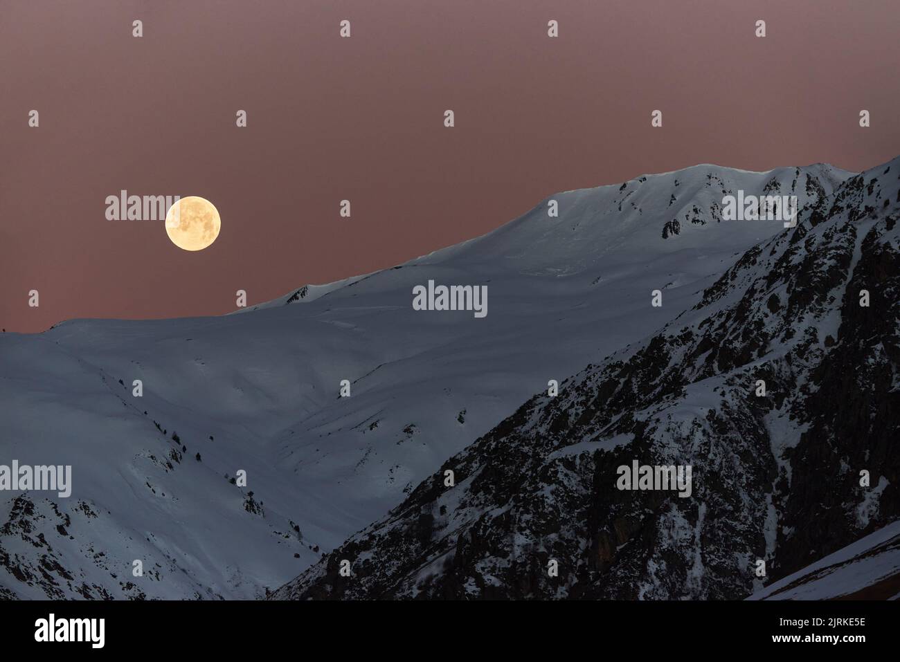 Full moon shining over snowy Pyrenees mountain range covered with snow ...
