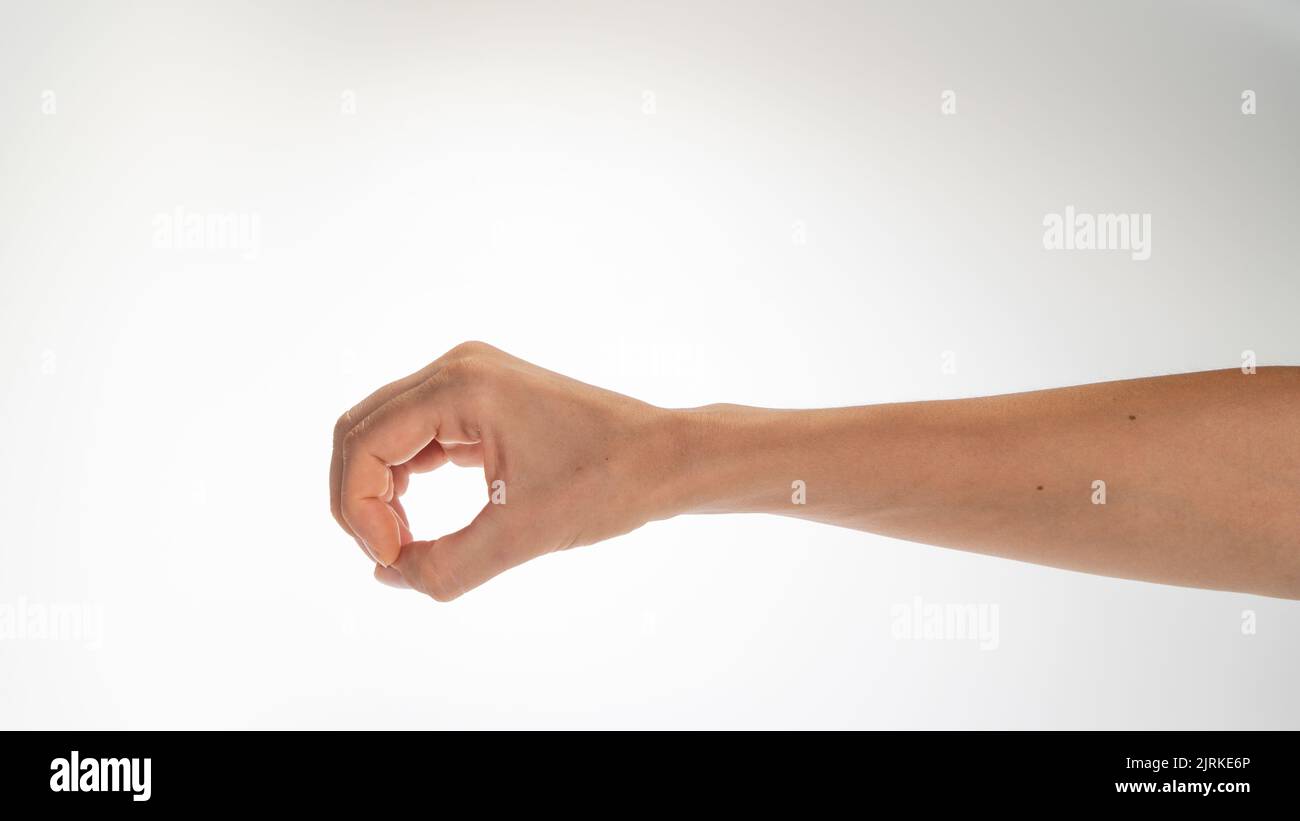 Hand woman gesture fingers clenched into a ring holding a cylindrical ...