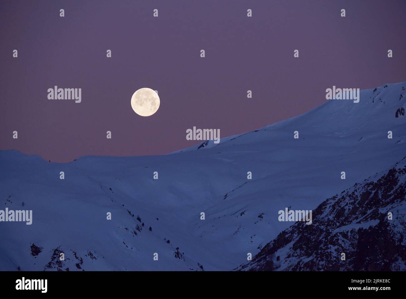 Full moon shining over snowy Pyrenees mountain range covered with snow ...