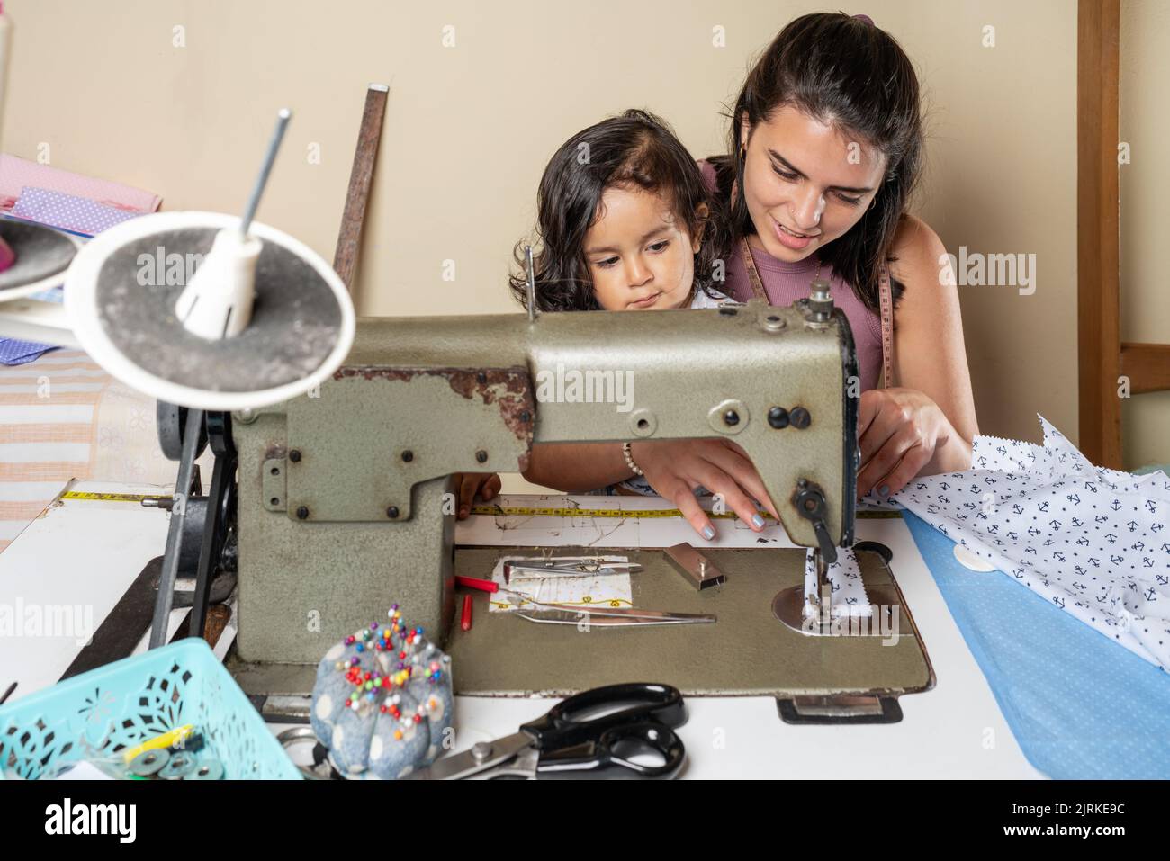 Cheerful Hispanic female with cute girl with smile sitting at ...