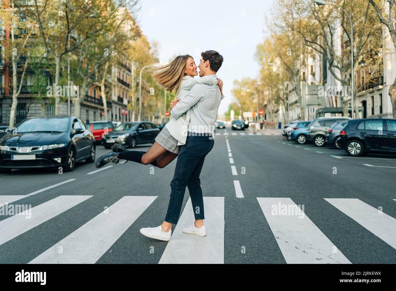 Delighted man spinning around smiling woman while having fun on ...
