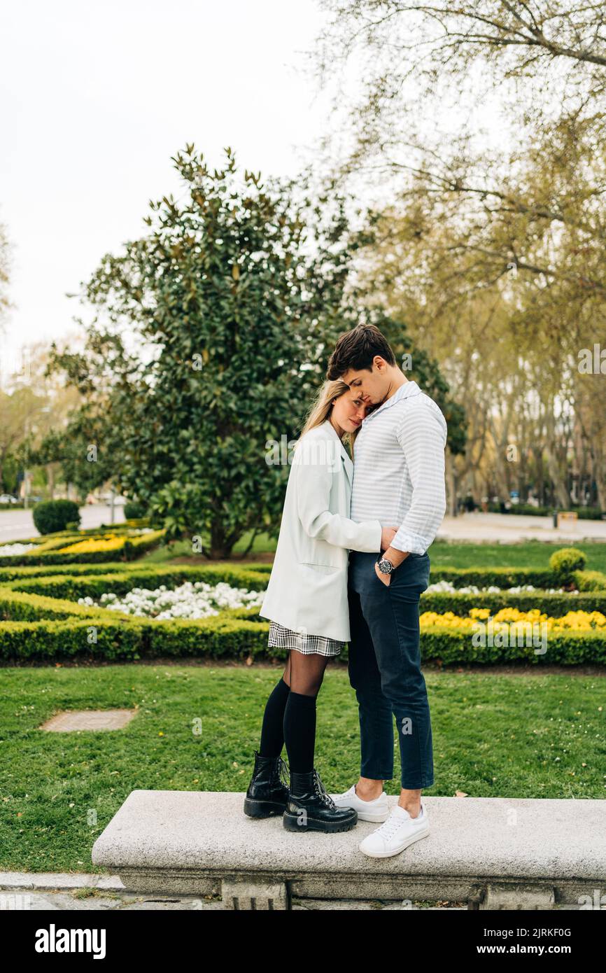 Side view of gentle couple hugging tenderly while standing in urban ...
