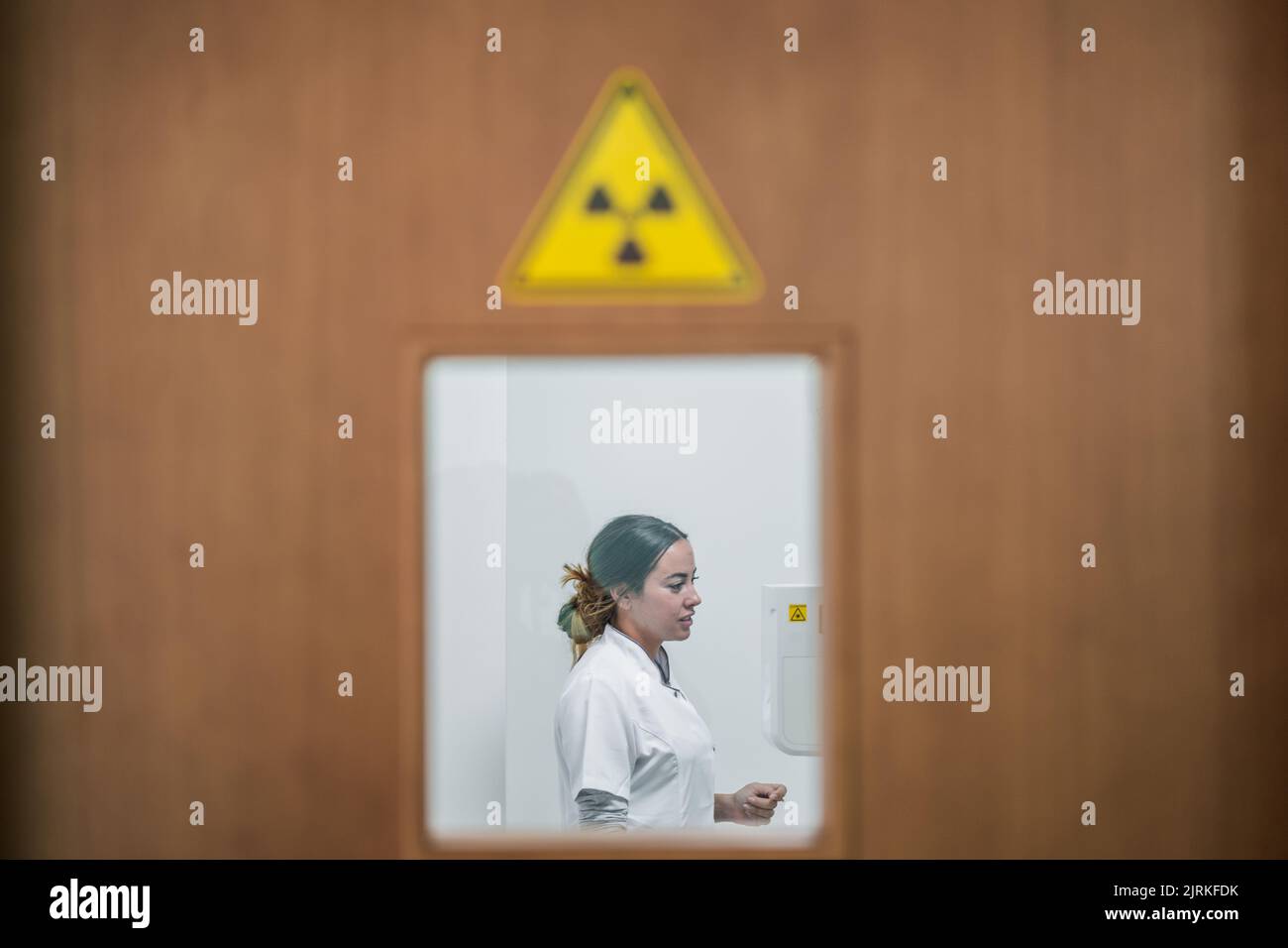Female dentist standing inside a dental clinic while looking away Stock ...