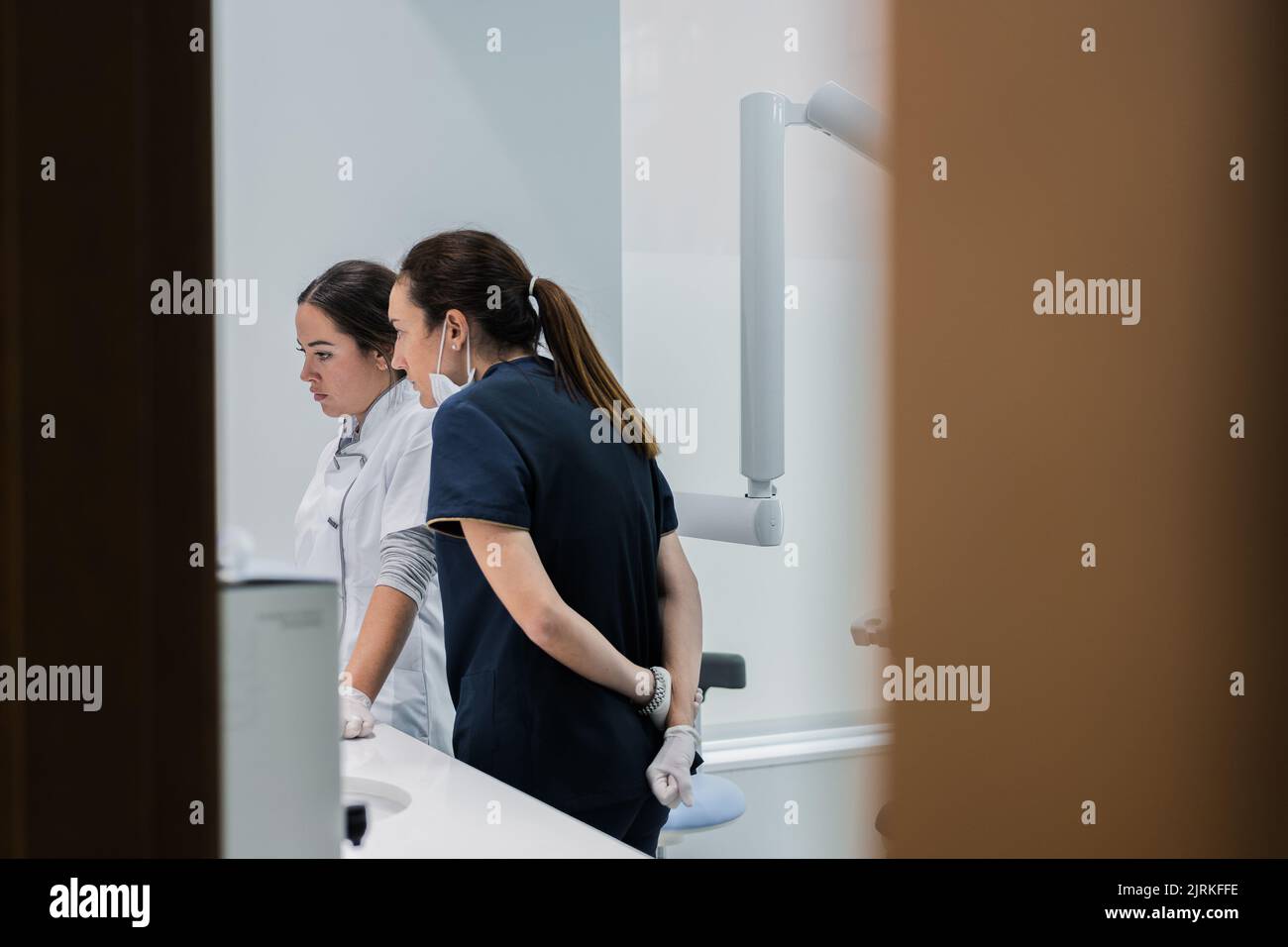 Side view of medical practitioners browsing data on modern computer ...