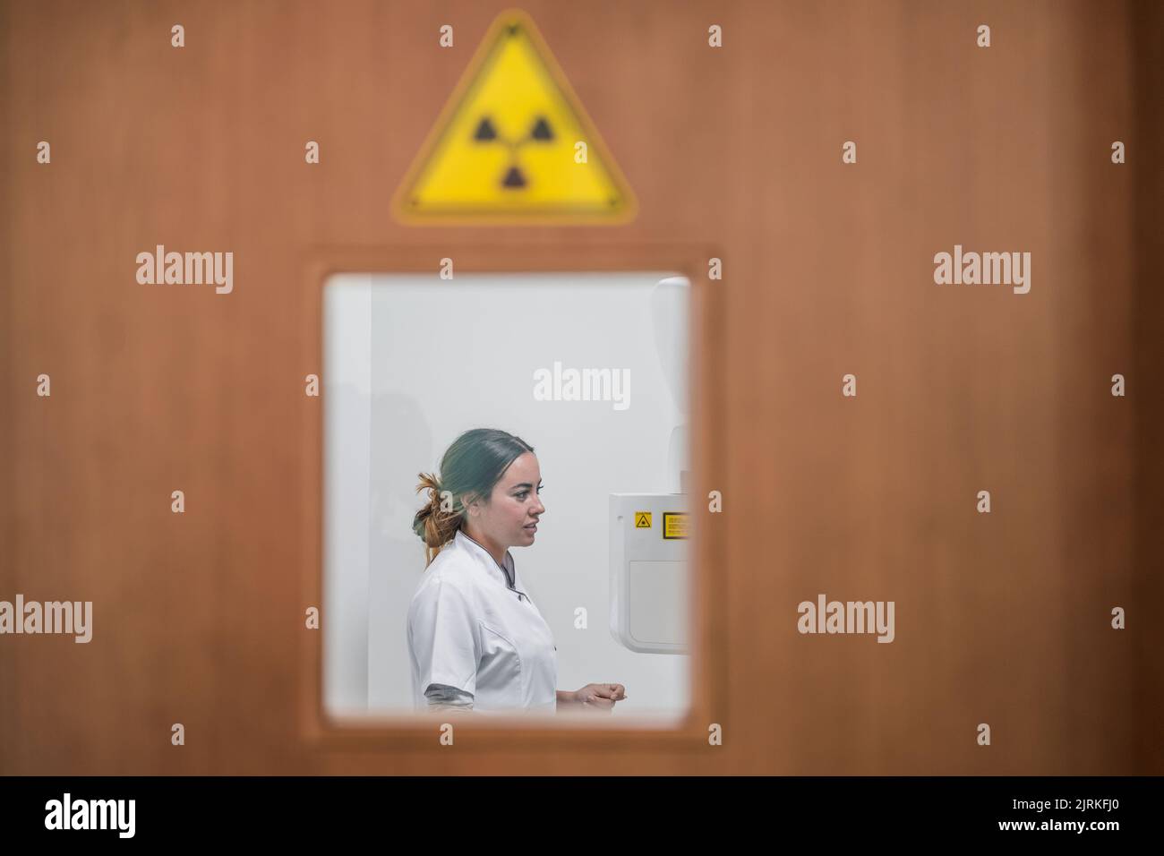 Female dentist standing inside a dental clinic while looking away Stock ...