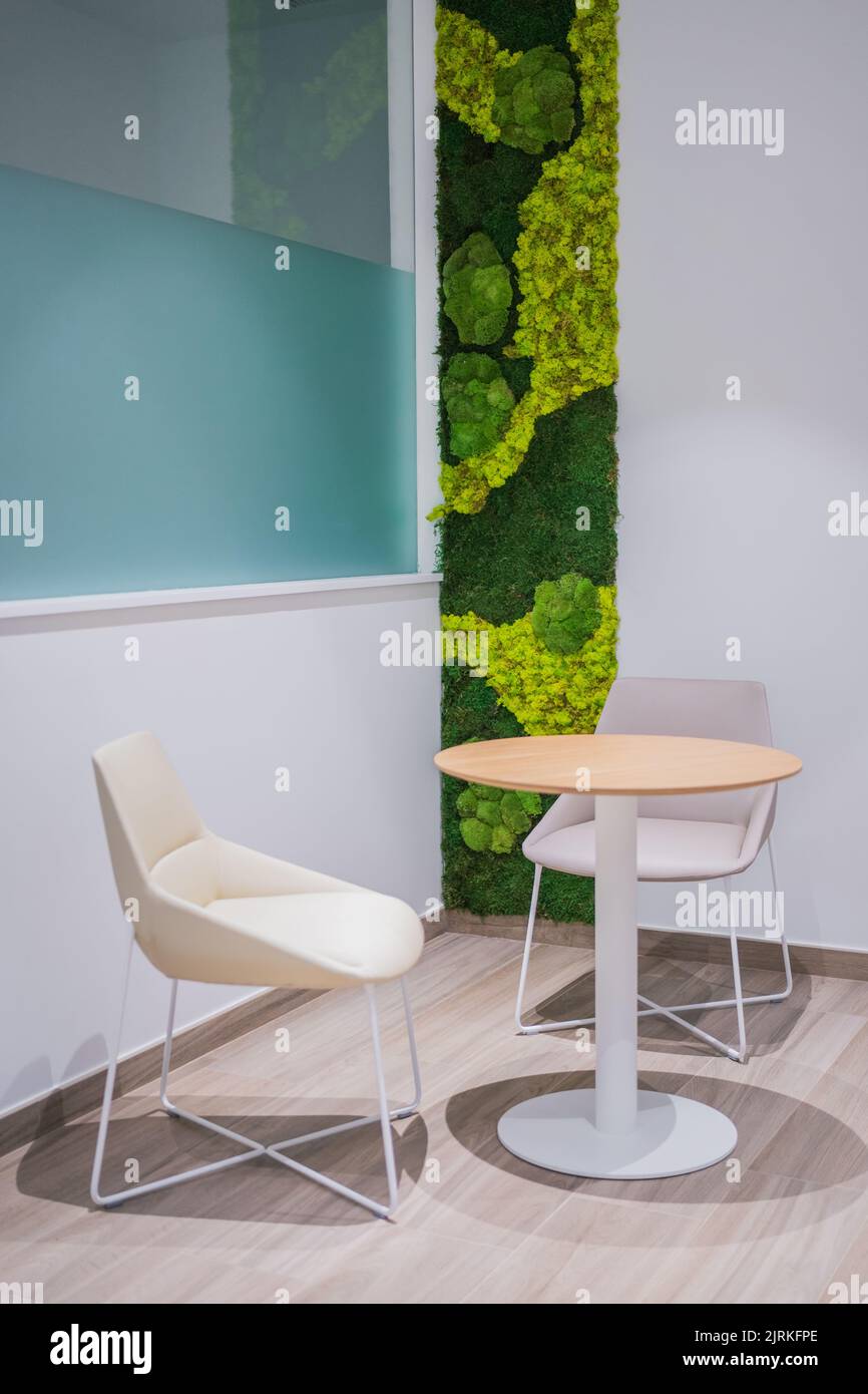 Comfortable chairs and round table located in waiting room of modern ...