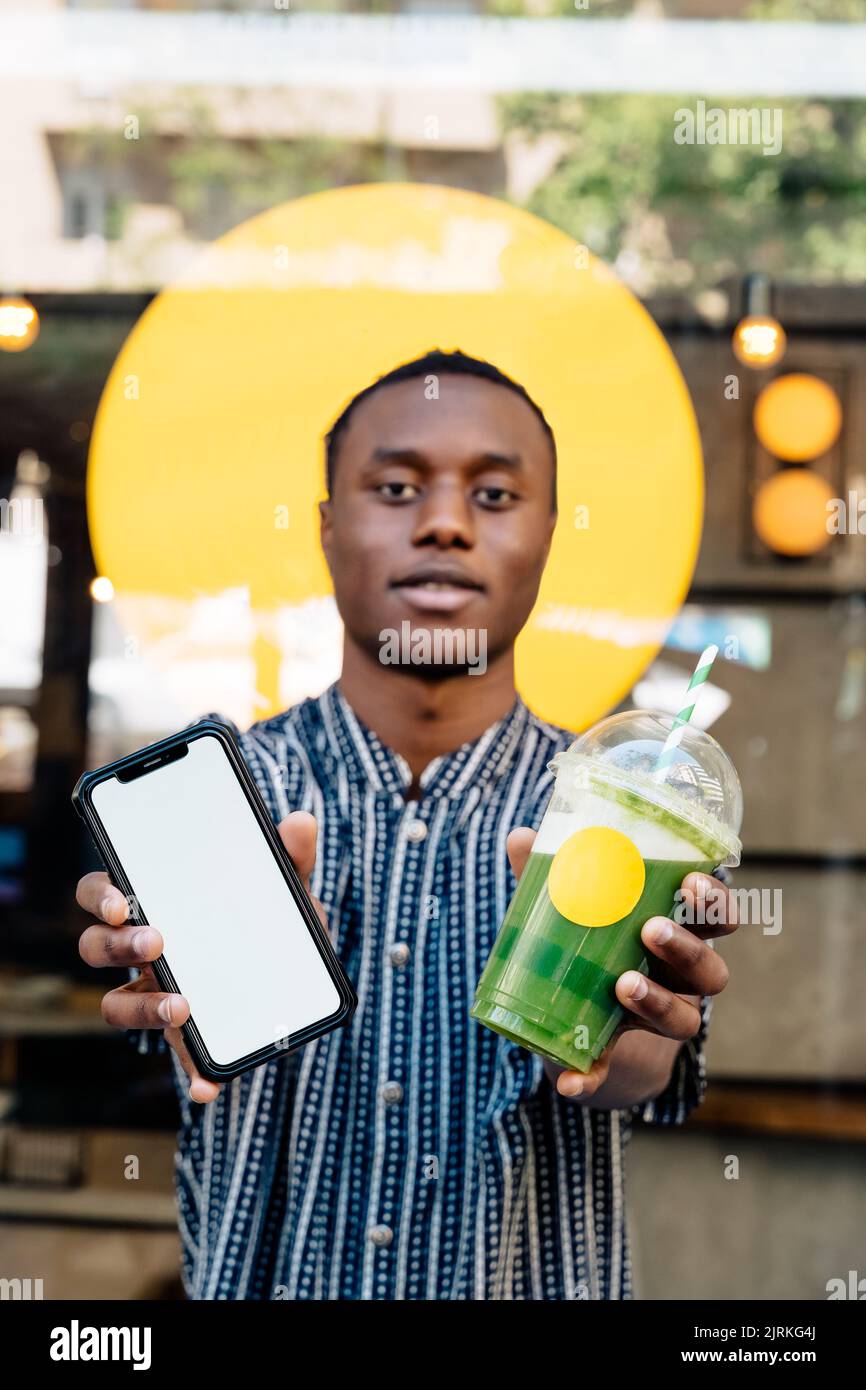 Content young black male demonstrating cellphone with blank screen and ...