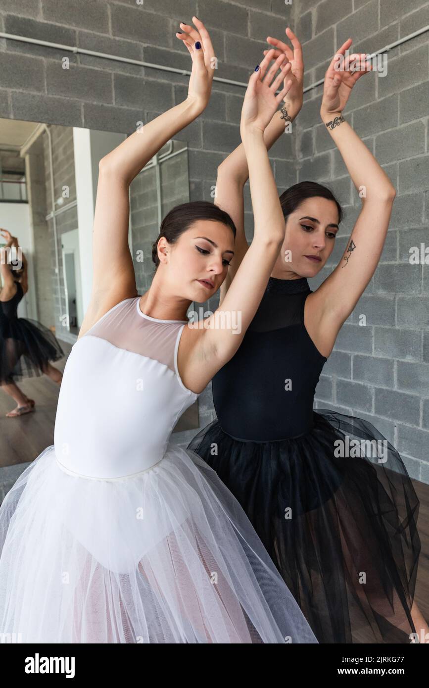photo of two elegant young ballerinas dancing in synchrony next to a ...