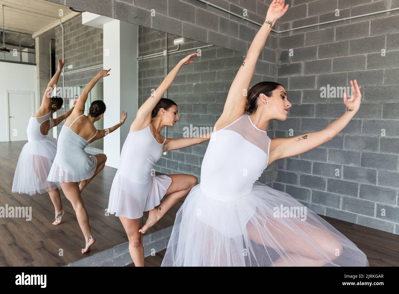 photo of two elegant young ballerinas dancing in synchrony next to a ...