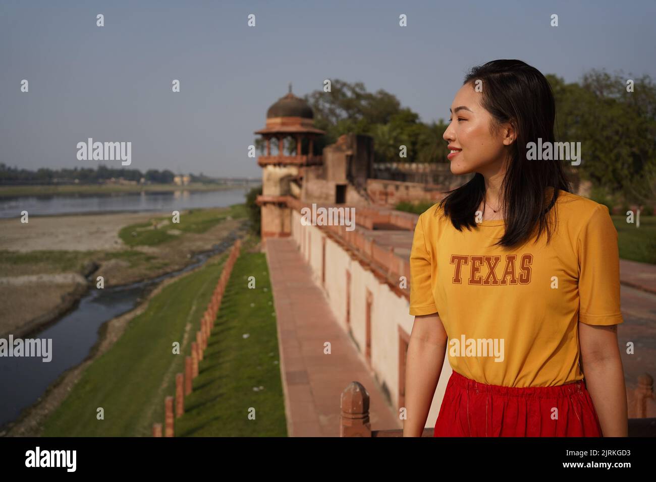 Ethnic asian female in casual clothes smiling and looking away while ...