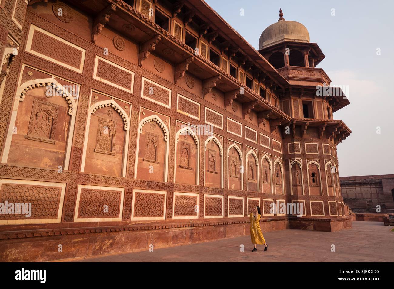 Full body woman looking away in yellow dress standing in aged Agra Fort ...