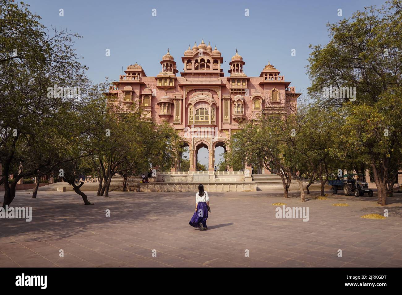 Back view of anonymous female traveler walking on pavement towards aged ...