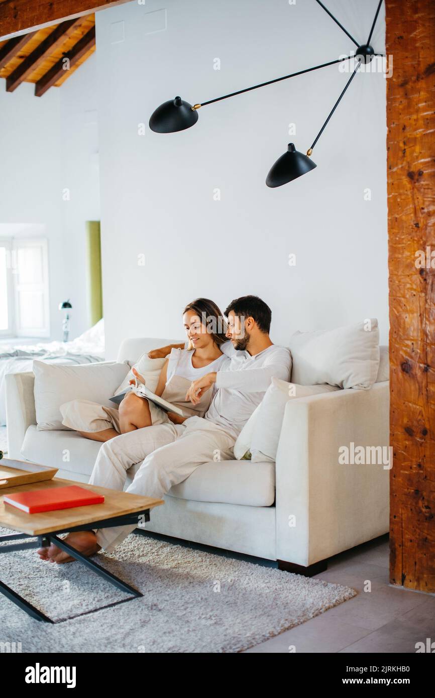 Unshaven husband dressed in domestic clothes hugging happy wife while ...