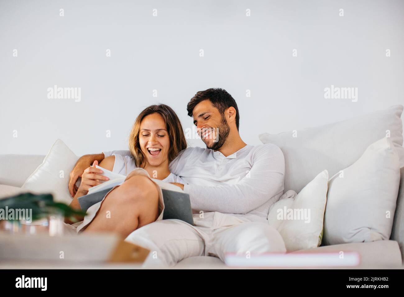 Unshaven husband dressed in domestic clothes hugging happy wife while ...