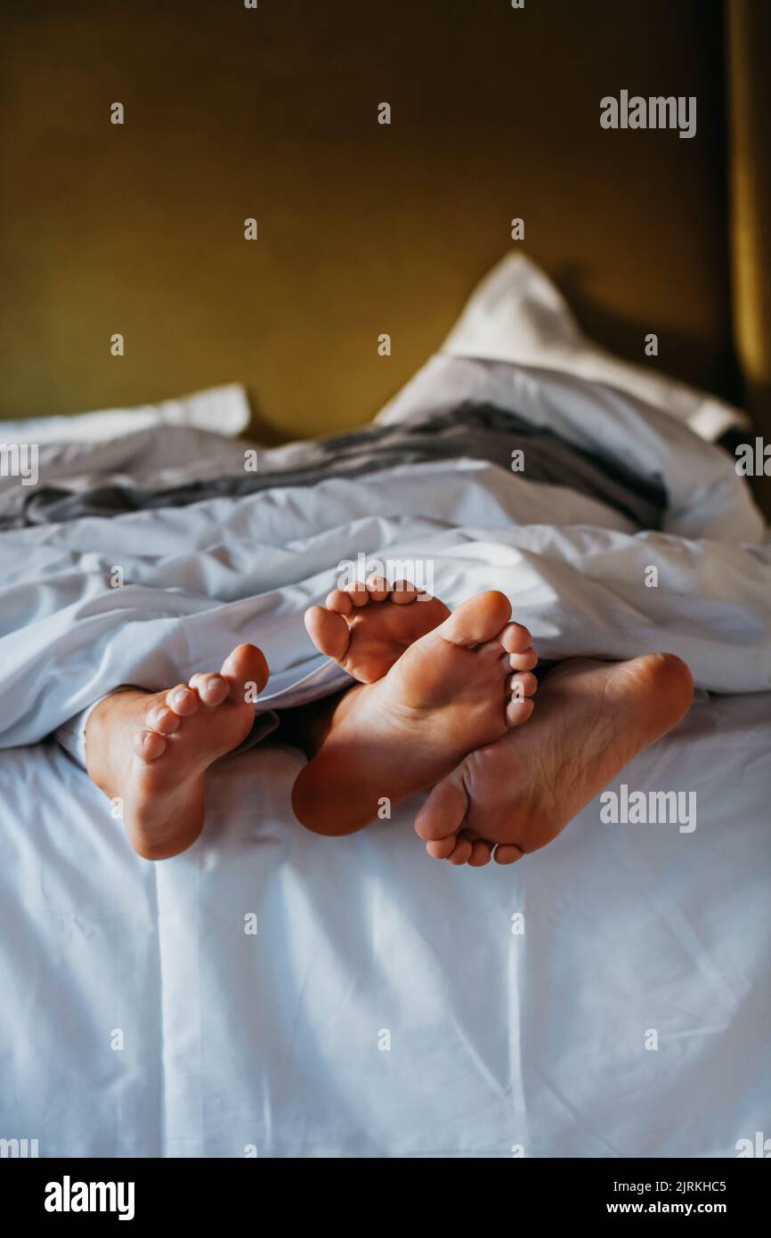 Crop Anonymous Barefoot Wife And Husband Cuddling Feet While Sleeping