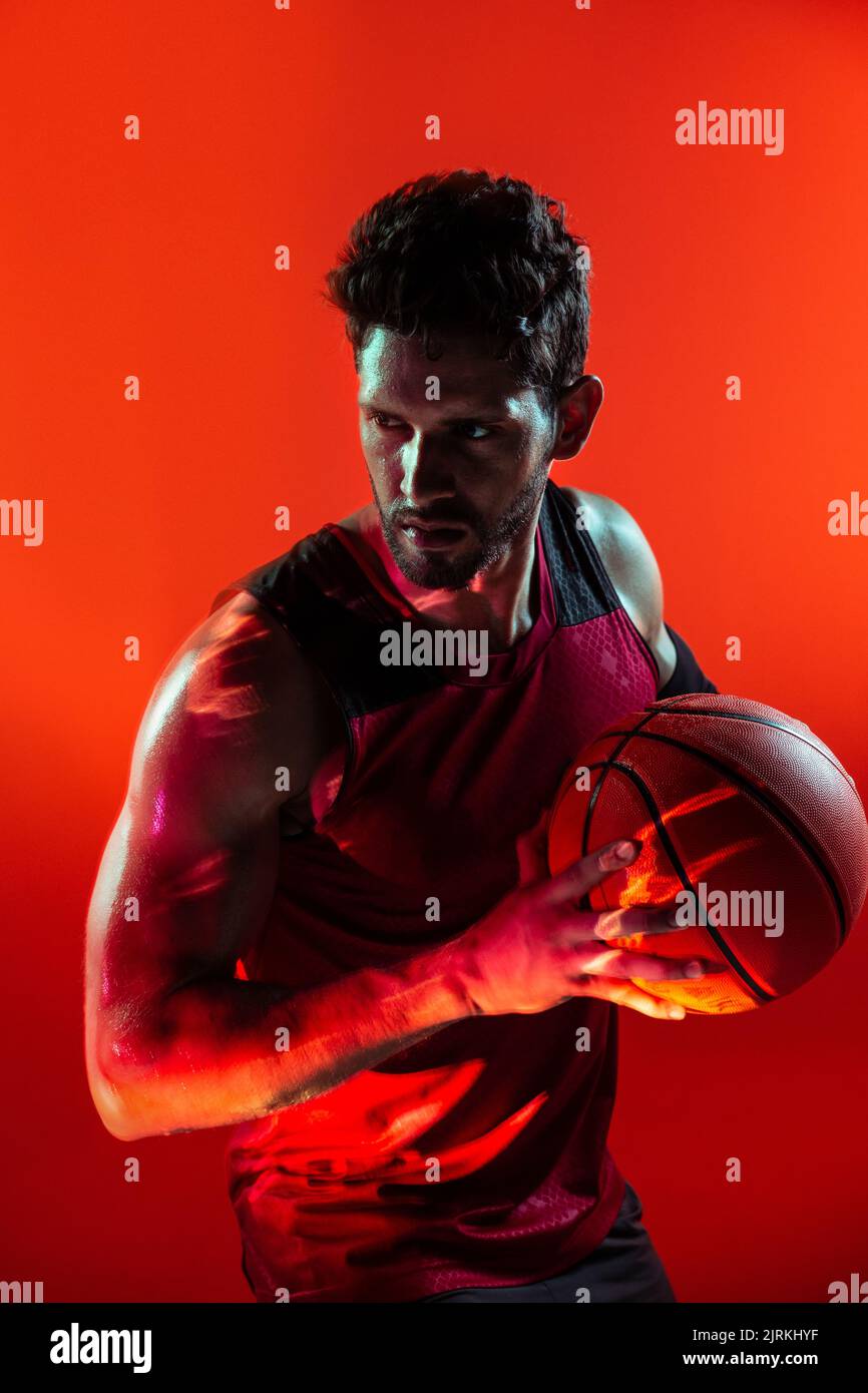 Creative studio shot of basketball player in studio using colored gels ...