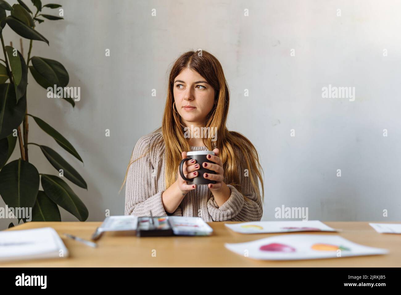 Artist having a cup of coffee with his drawings Stock Photo - Alamy