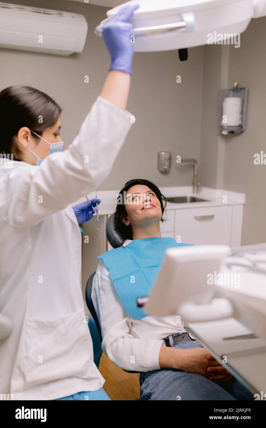 Side view unrecognizable stomatologist in uniform near cheerful female ...