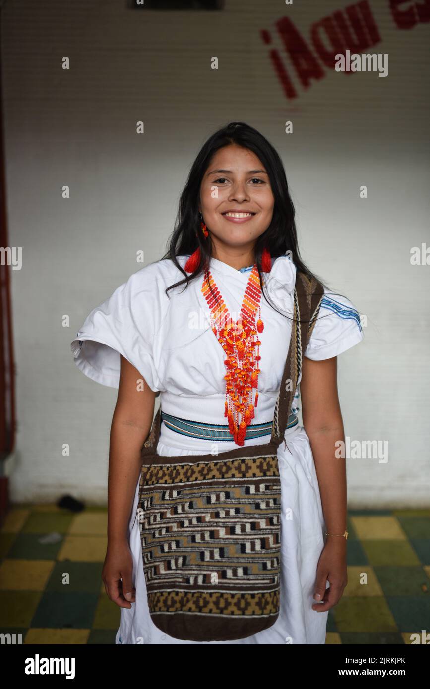 Portrait of happy young Arhuaco indigenous woman in a urban environment ...