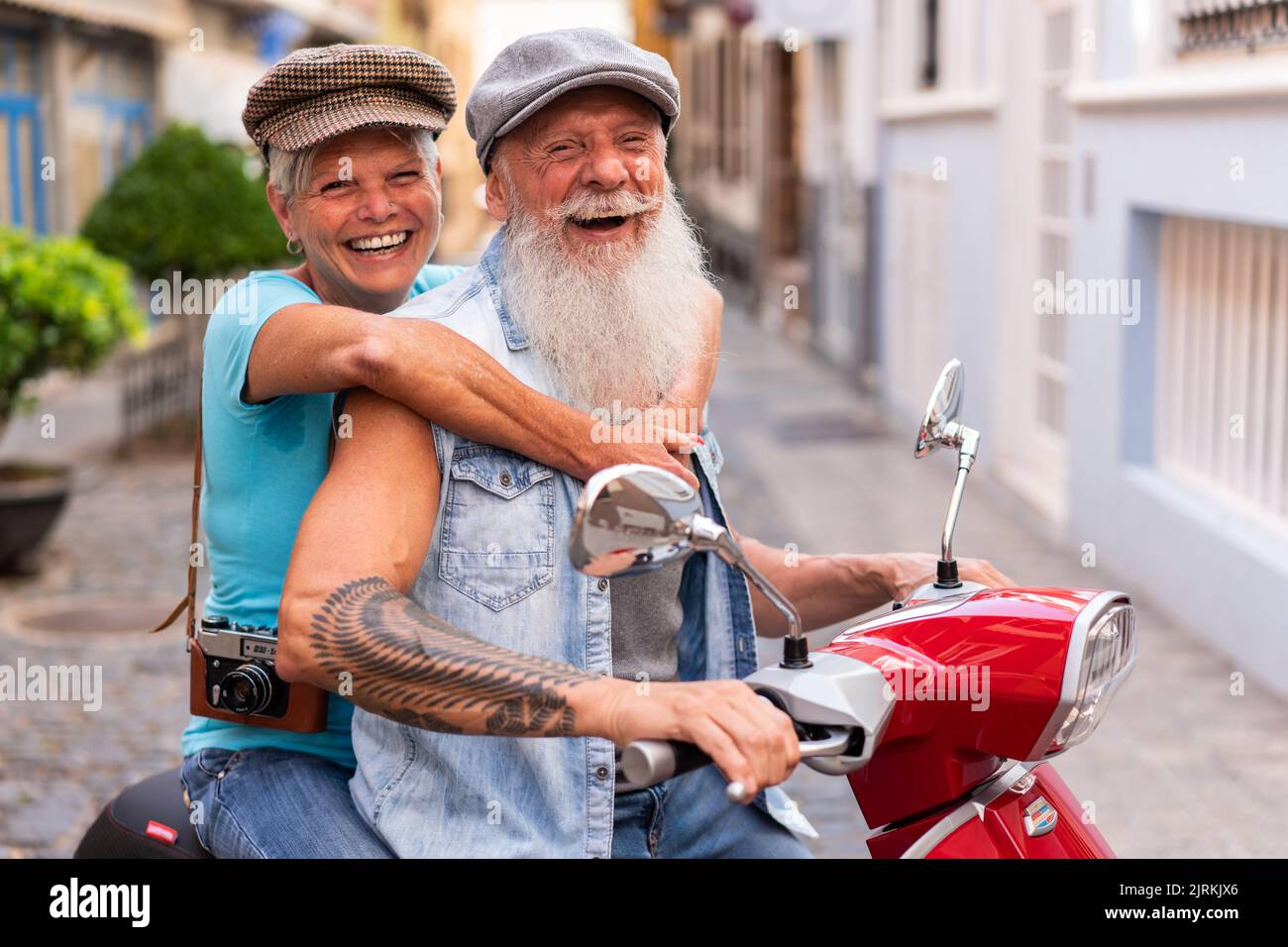 Front view of a modern senior couple riding on a motorcycle while ...