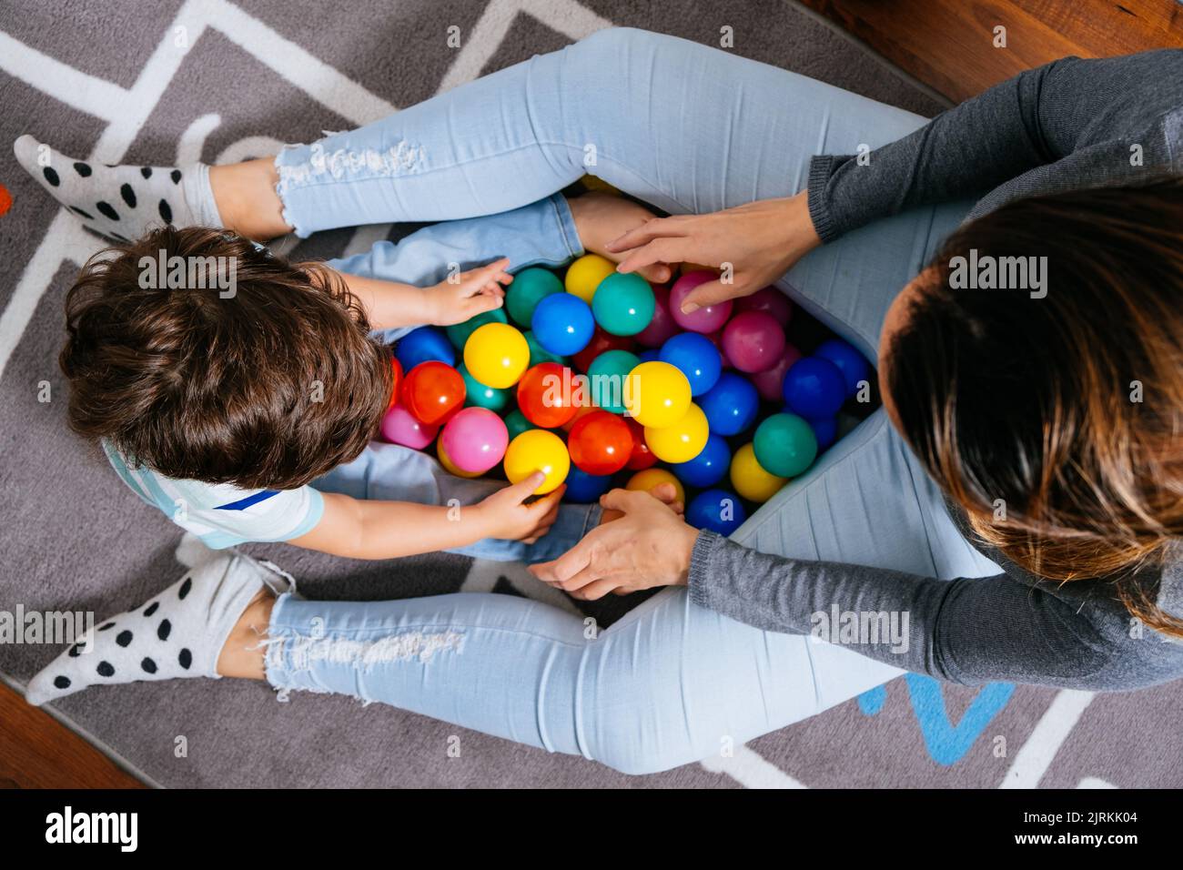 Top view of unrecognizable adult woman and little boy sitting on ...