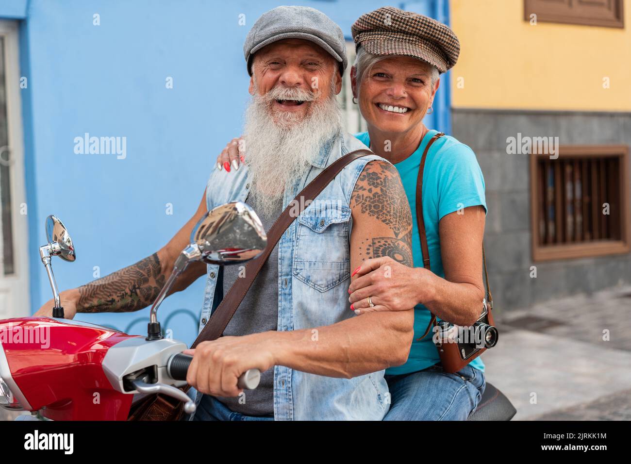 Side view of a modern senior couple riding on a motorcycle while ...