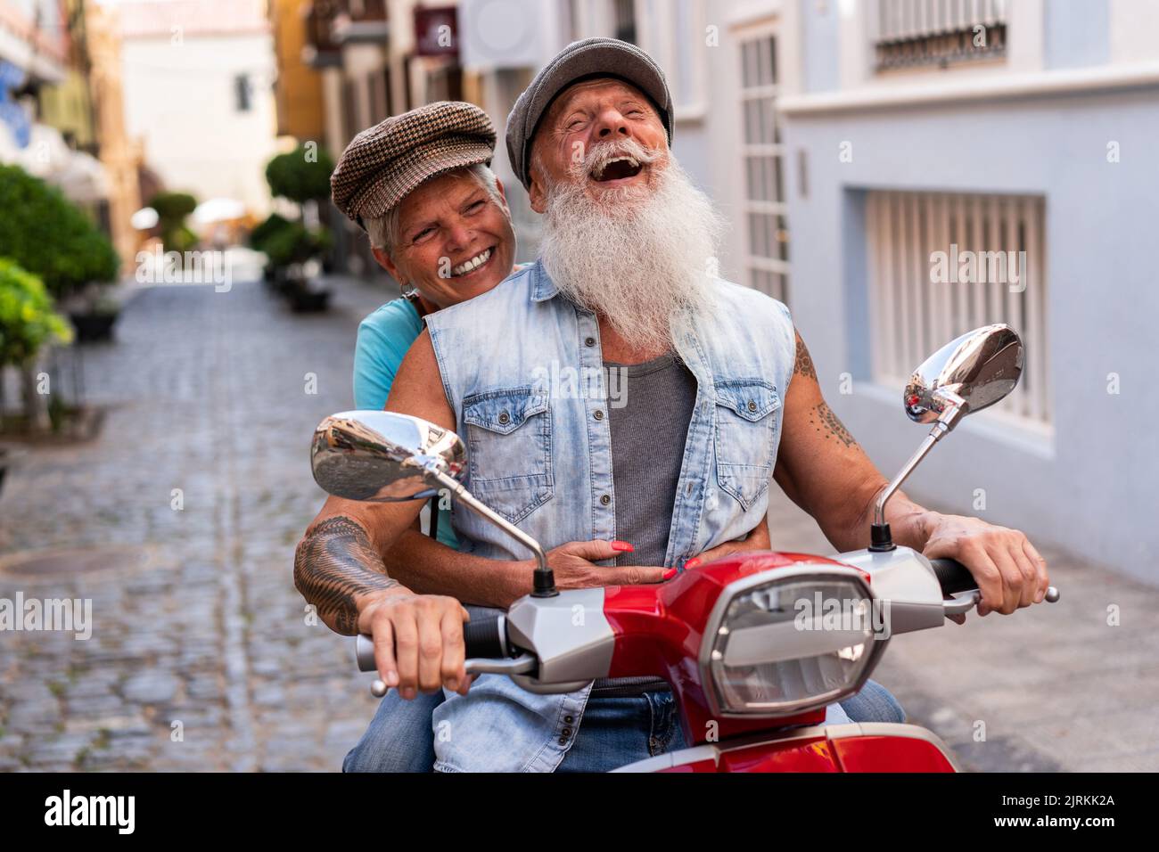 Front view of a modern senior couple riding on a motorcycle while ...