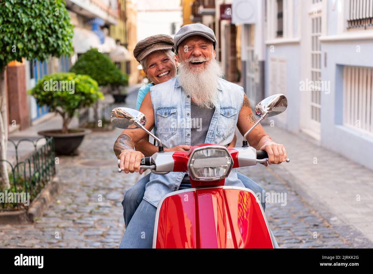 Front view of a modern senior couple riding on a motorcycle while ...